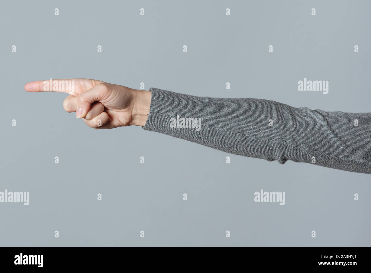Female hand showing ahead by index finger isolated on gray background ...
