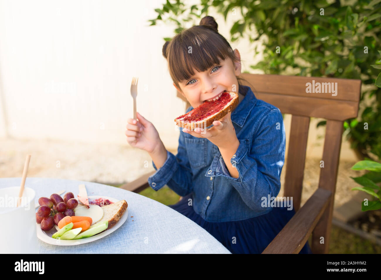 Healthy Girl Biting a Bread With Jam Stock Photo - Alamy