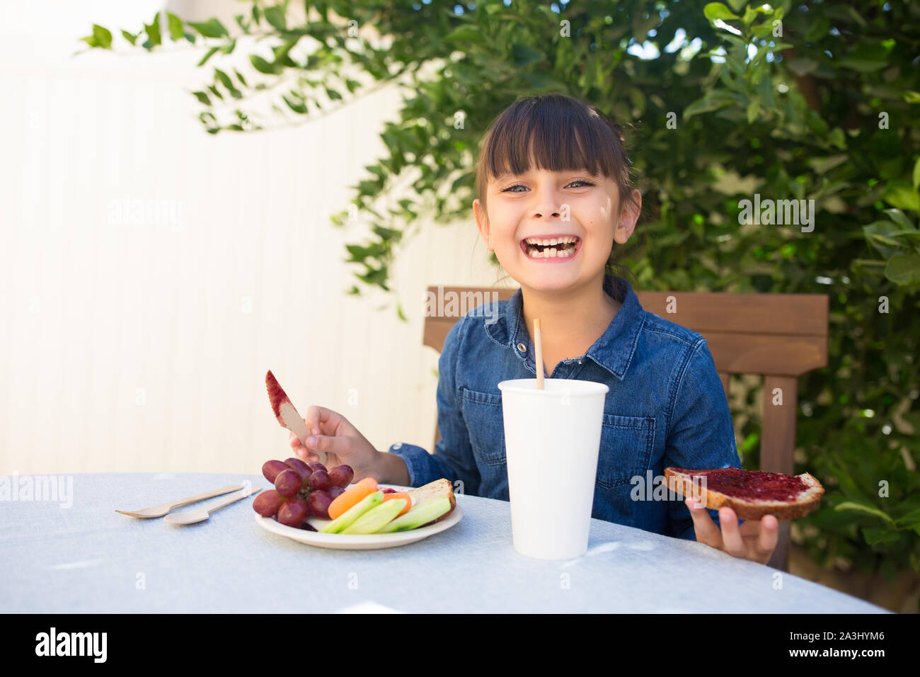 Girl with a toothy smile eating healthy food Stock Photo - Alamy