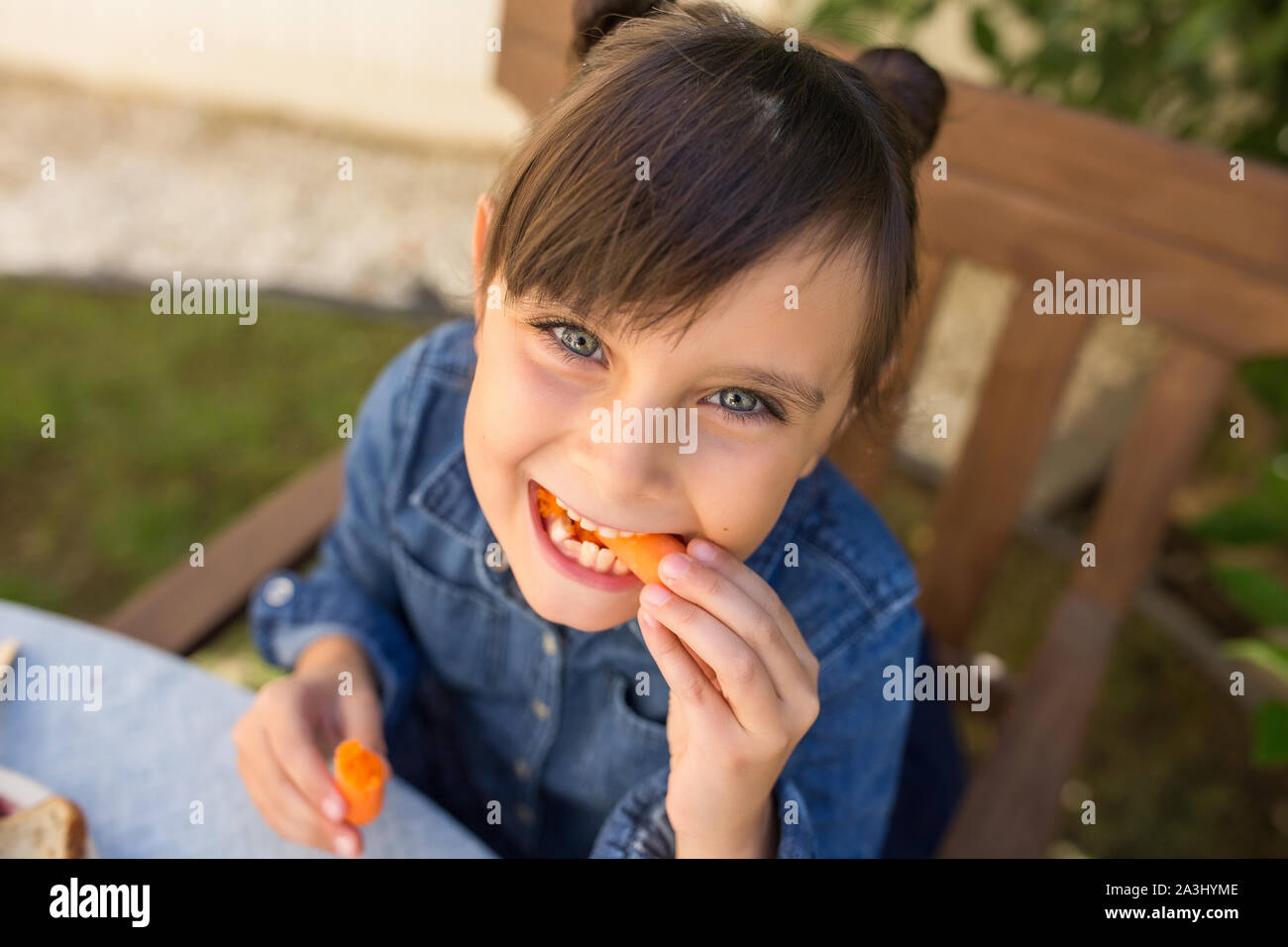 Girl biting healthy carrot sticks Stock Photo - Alamy