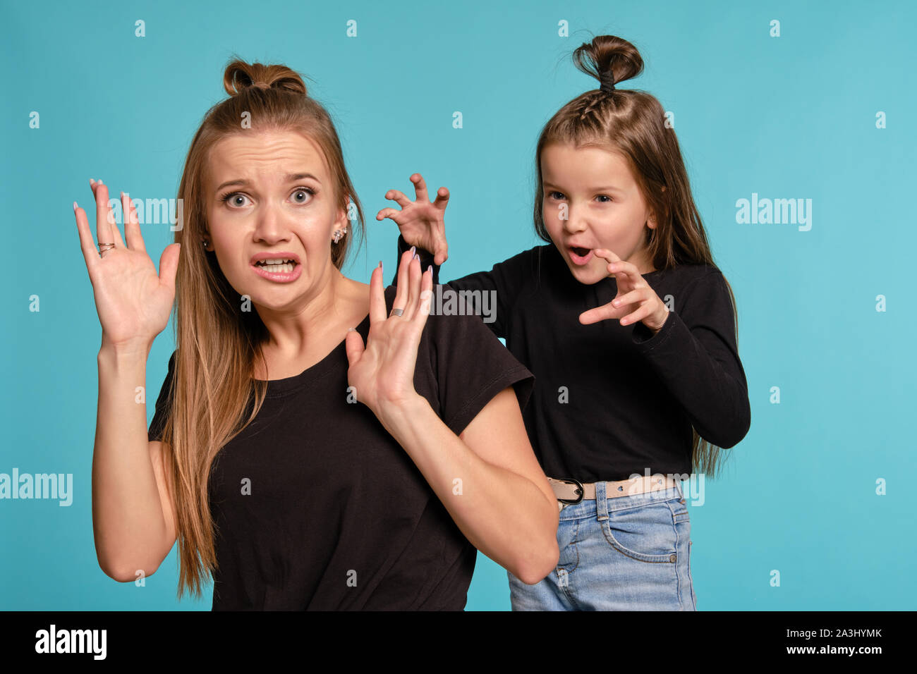Mom and daughter with a funny hairstyles, dressed in black shirts and ...