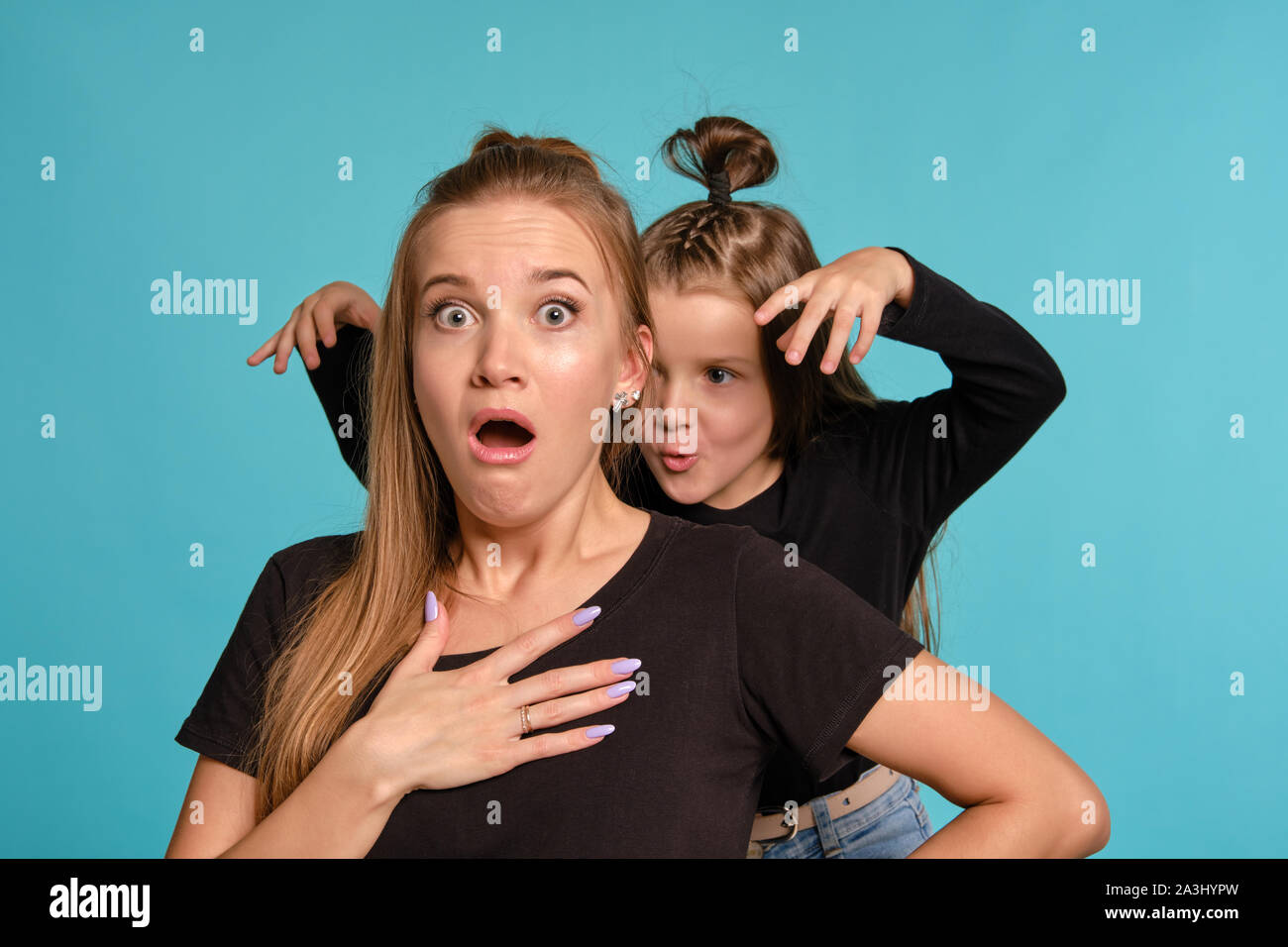 Mom and daughter with a funny hairstyles, dressed in black shirts and ...