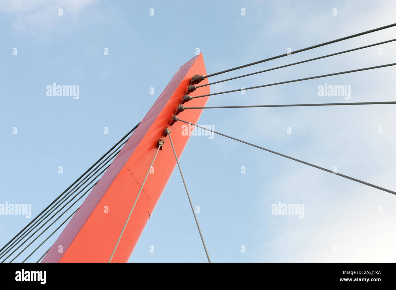 Cable bridge pole in red and cables in different angles on blue sky ...