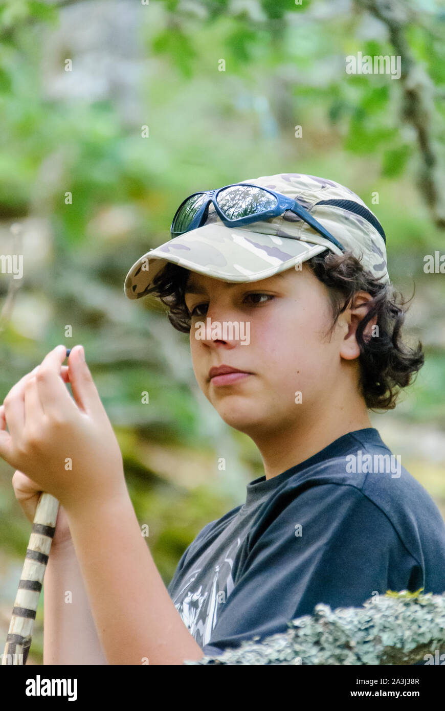 Young teenage girl with a stick looks at a blueberry in her hand Stock ...