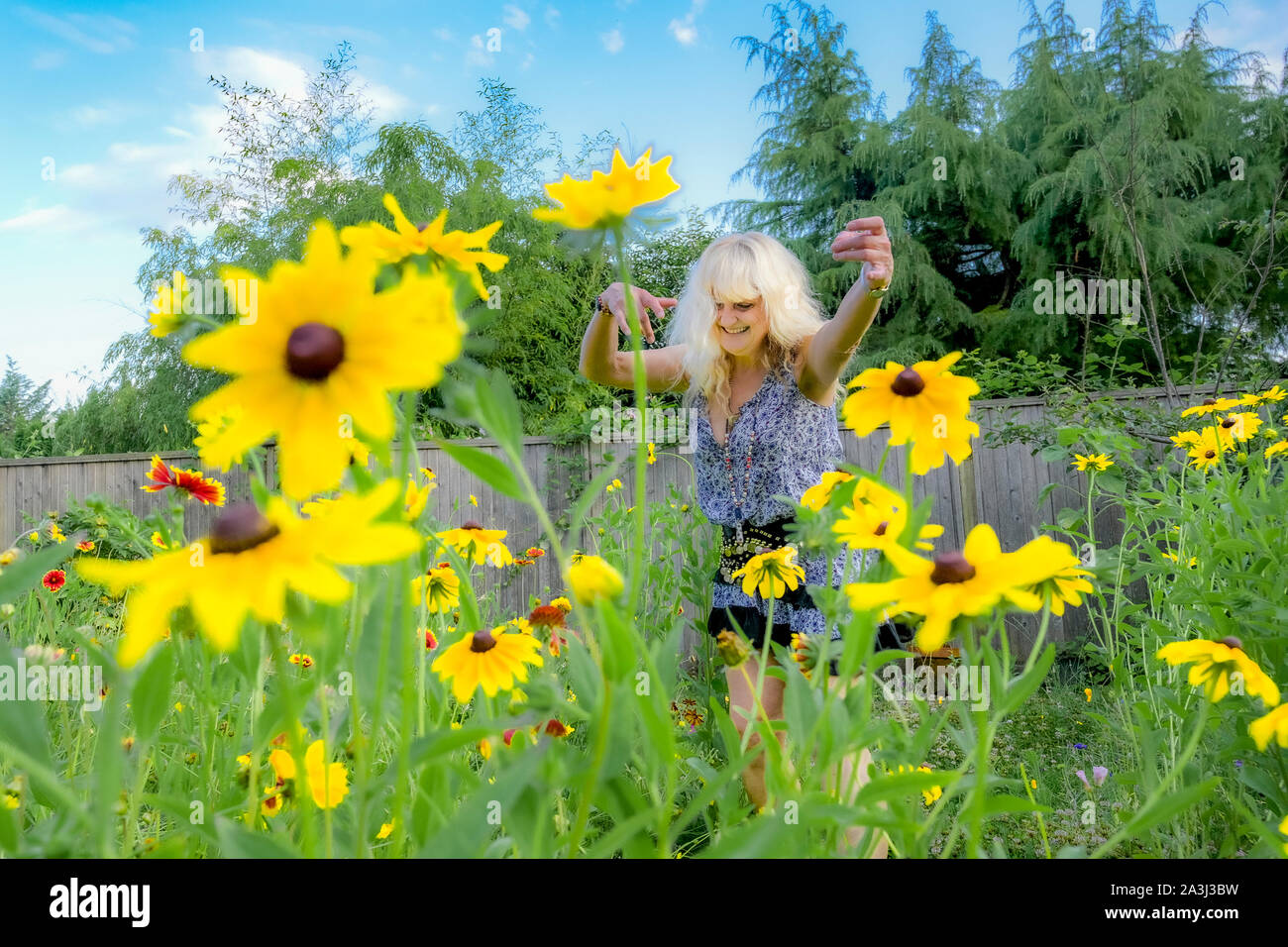 Woman dancing in wildflowers Stock Photo - Alamy