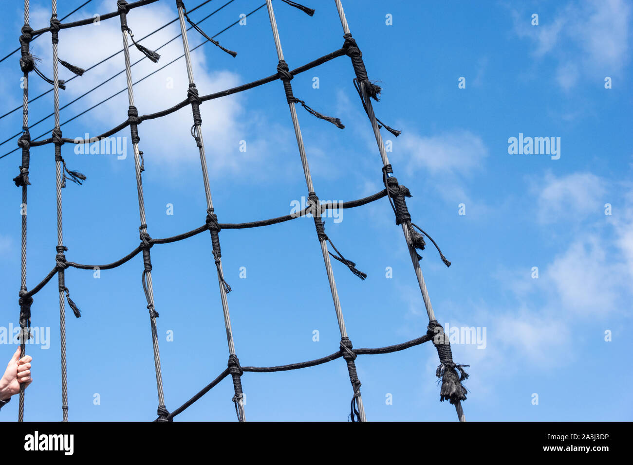 ship rigging on a blue sky background with the hand holding the line ...