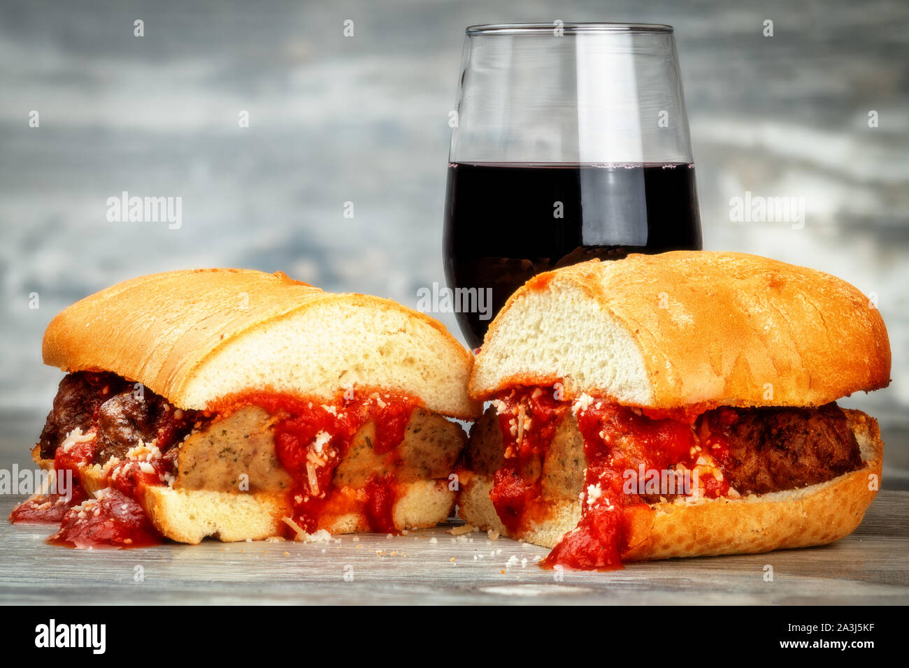 Wine in a fancy glass behind a submarine sandwich Stock Photo - Alamy