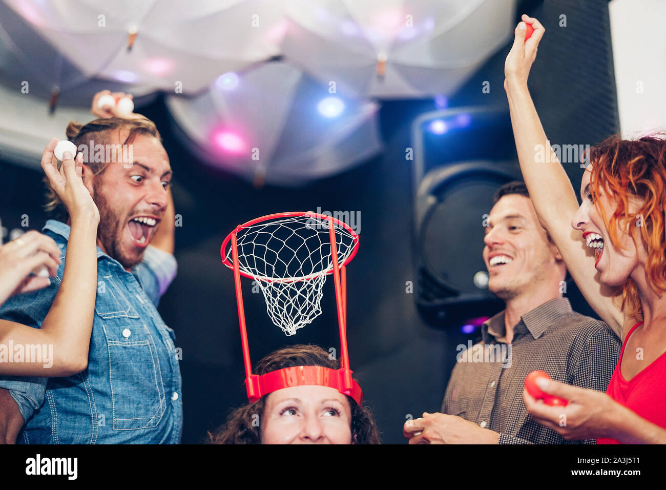 Group of friends playing funny basketball games inside a pub cocktail ...