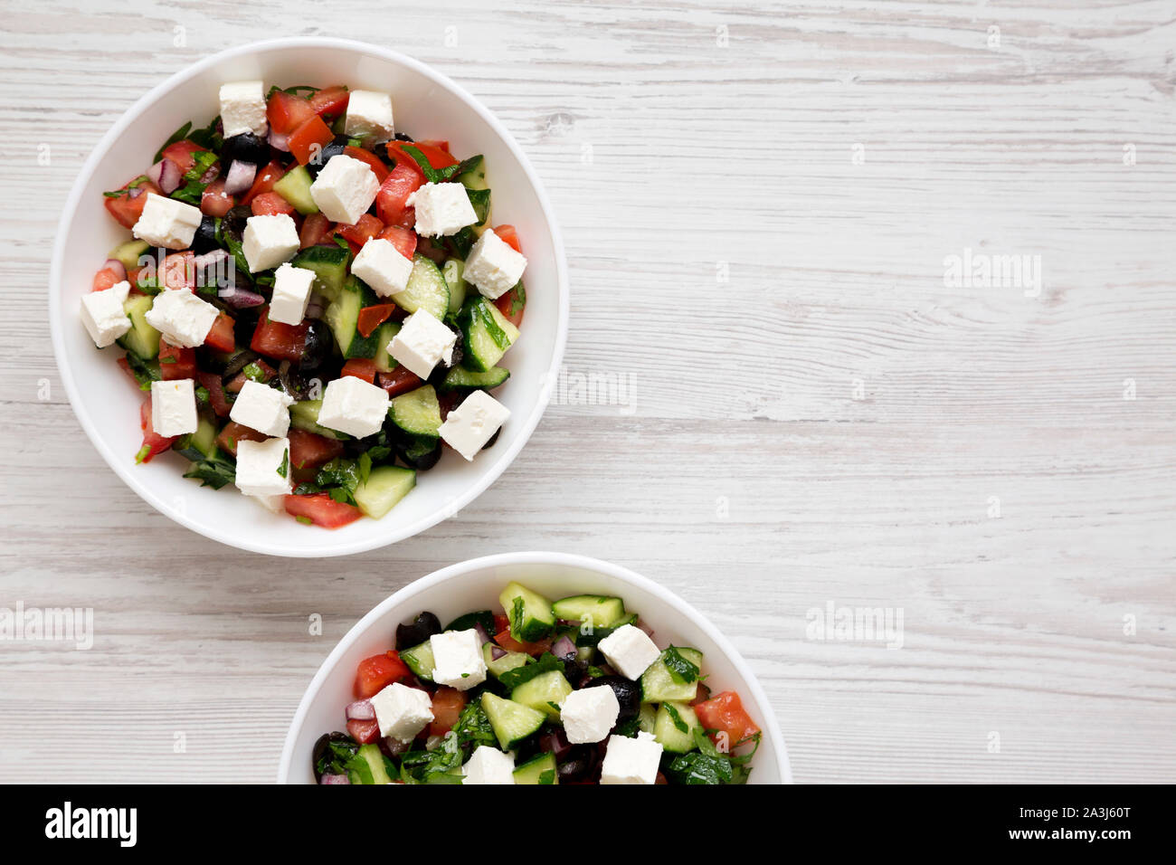 Homemade Shepherd's salad with cucumbers, feta and parsley in white ...