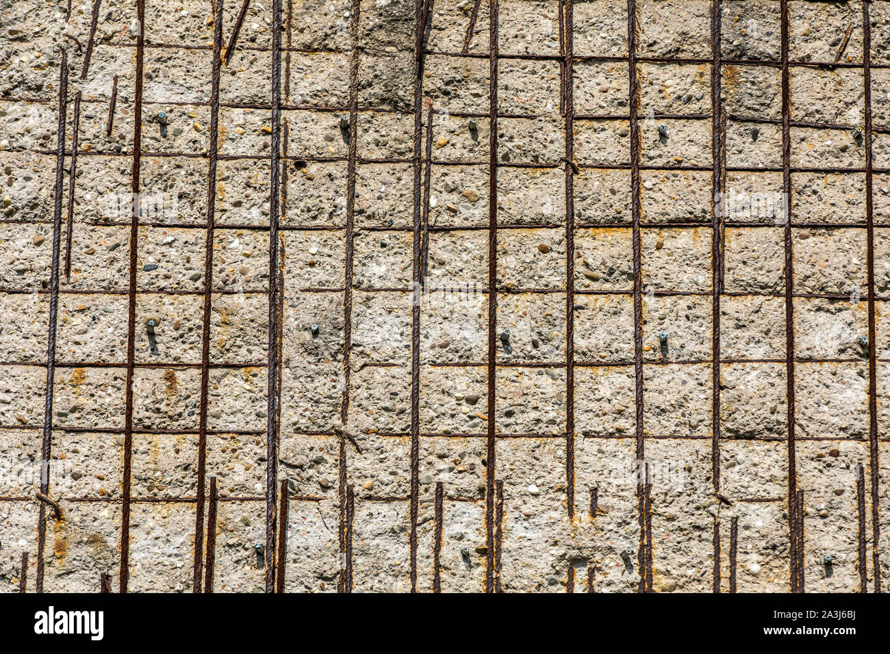 Concrete wall, chipped concrete, the reinforcing irons become visible ...