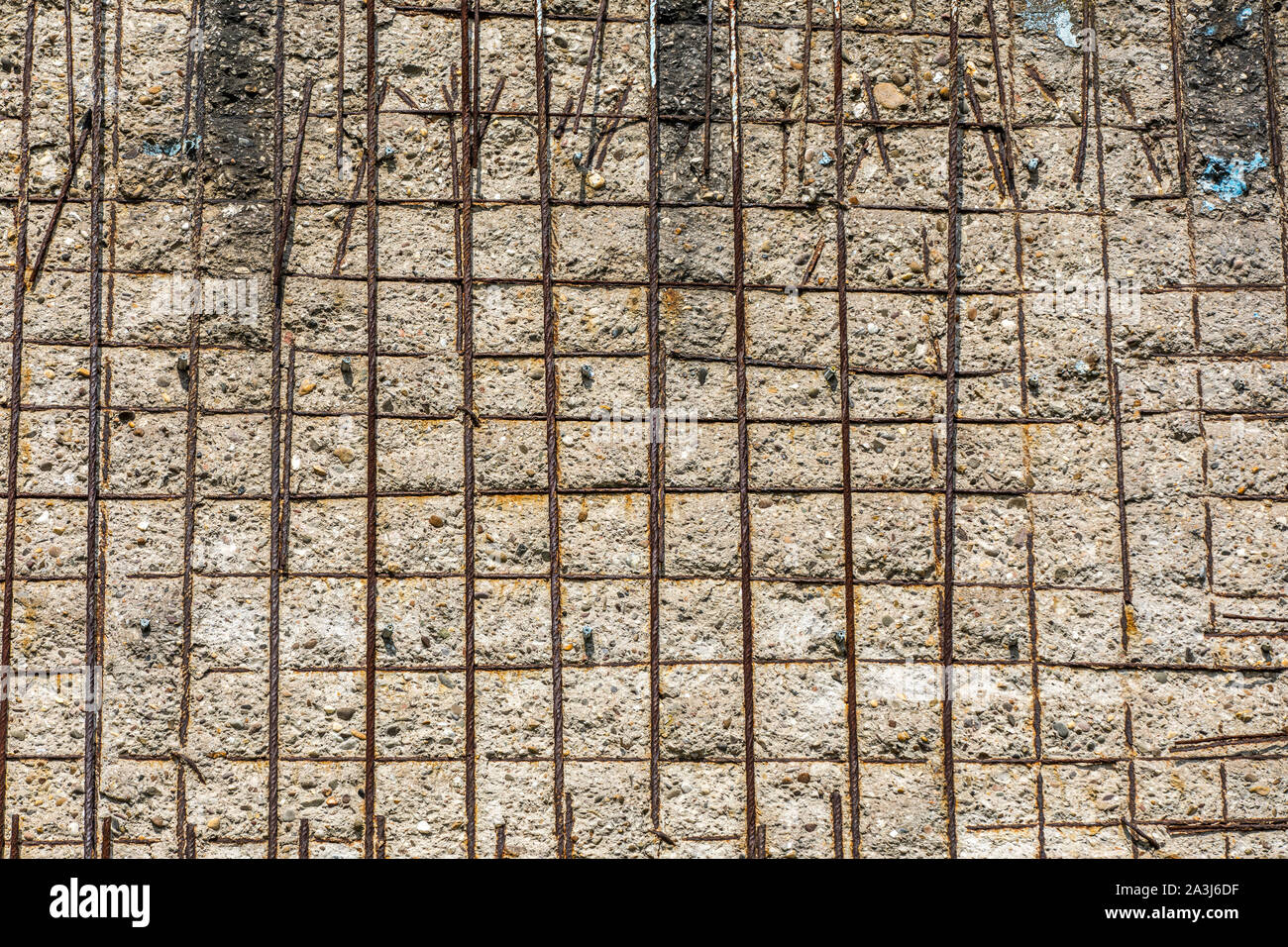 Concrete wall, chipped concrete, the reinforcing irons become visible ...