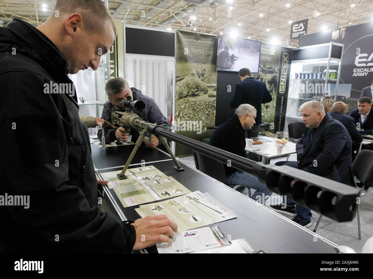 Kiev, Ukraine. 08th Oct, 2019. A man tests a gun during the exhibition ...