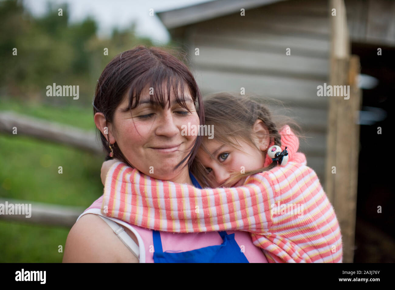 Young girl with her arms around her mother's neck Stock Photo - Alamy