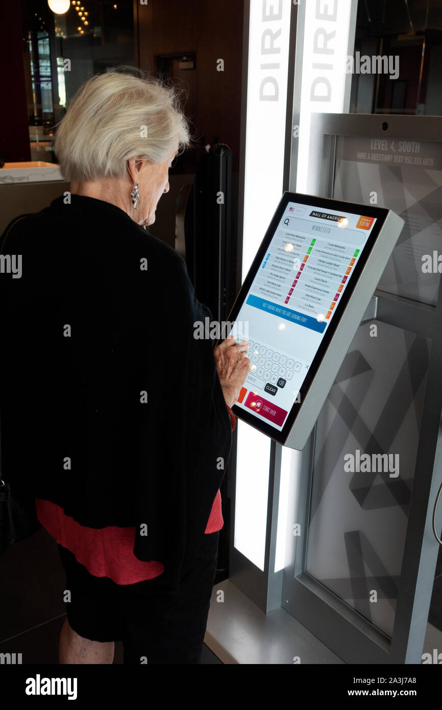 Senior citizen woman electronically selecting a movie at the AMC ...