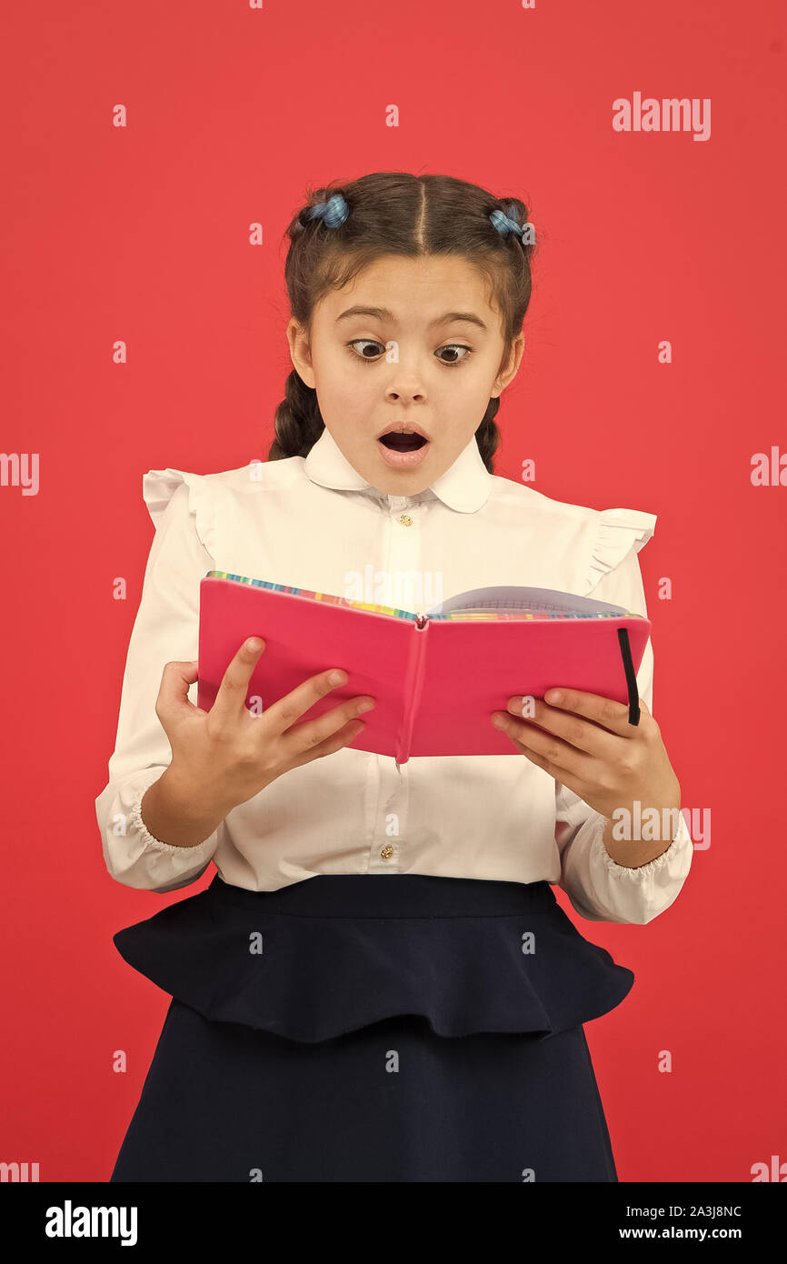 What a surprise news. Surprised girl reading book on red background ...