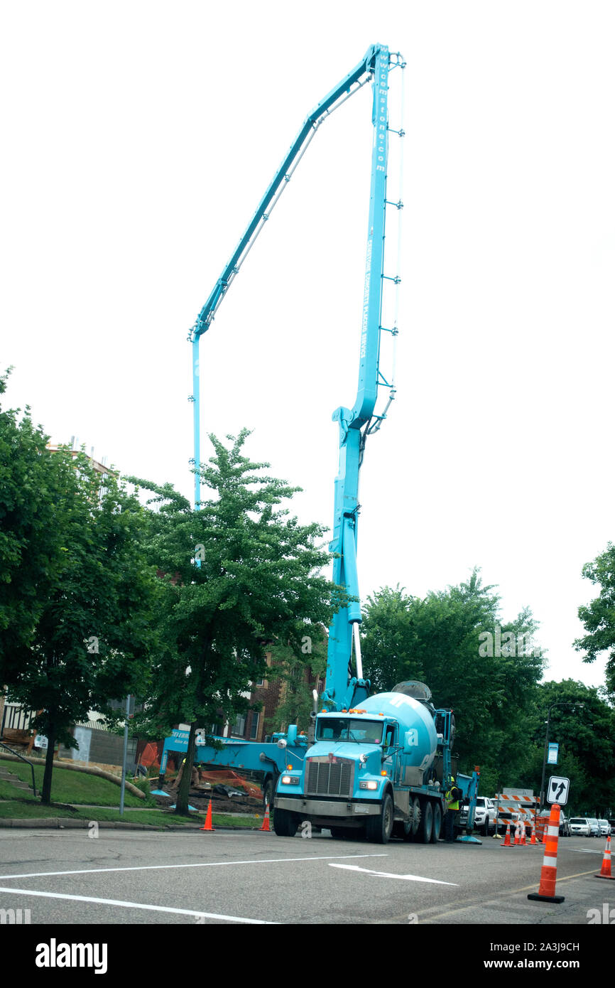 Truck delivering cement thru a very extended boom for a construction ...