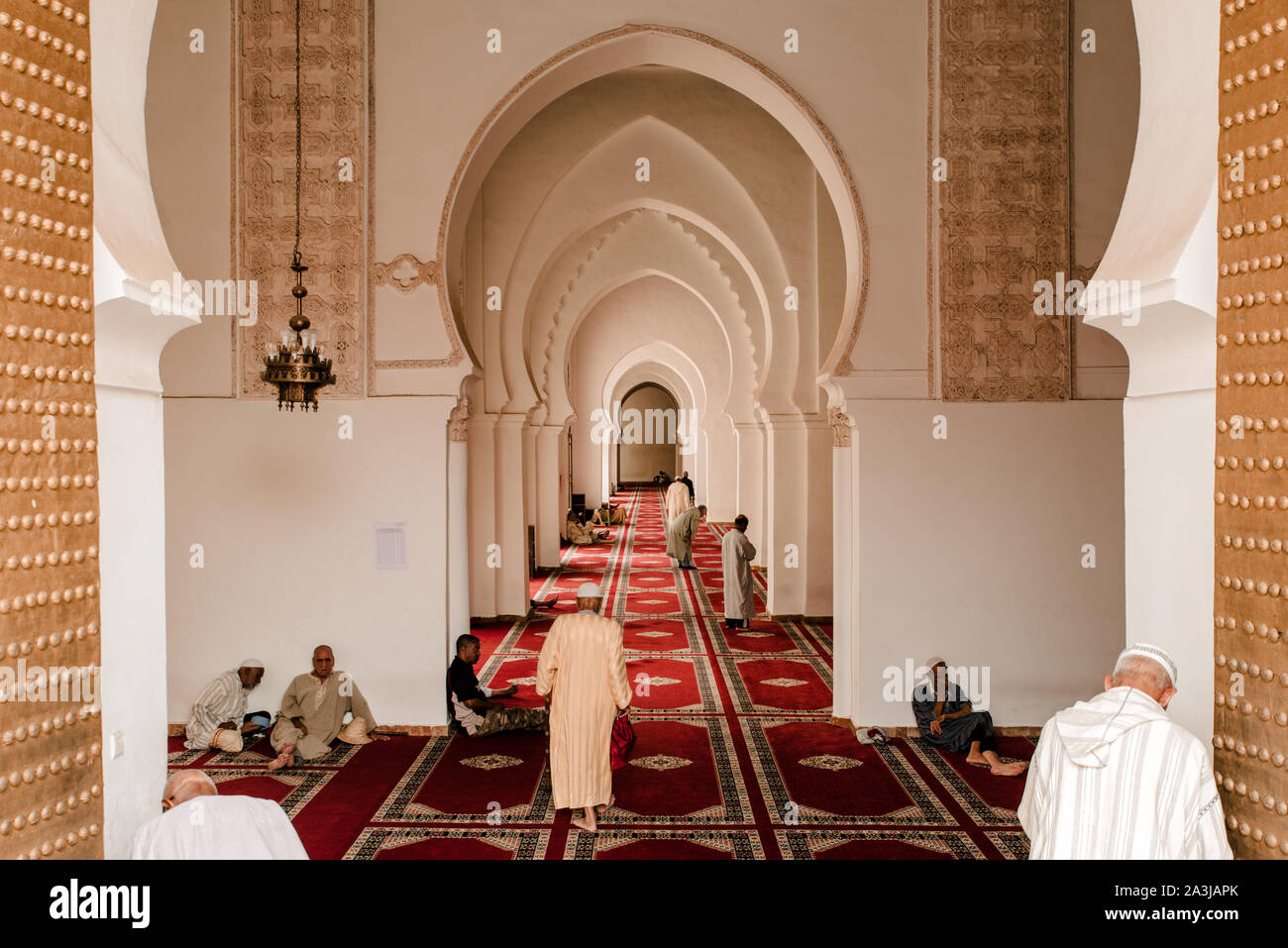 Several Muslim men barefoot inside a mosque in Marrakech in Morocco ...
