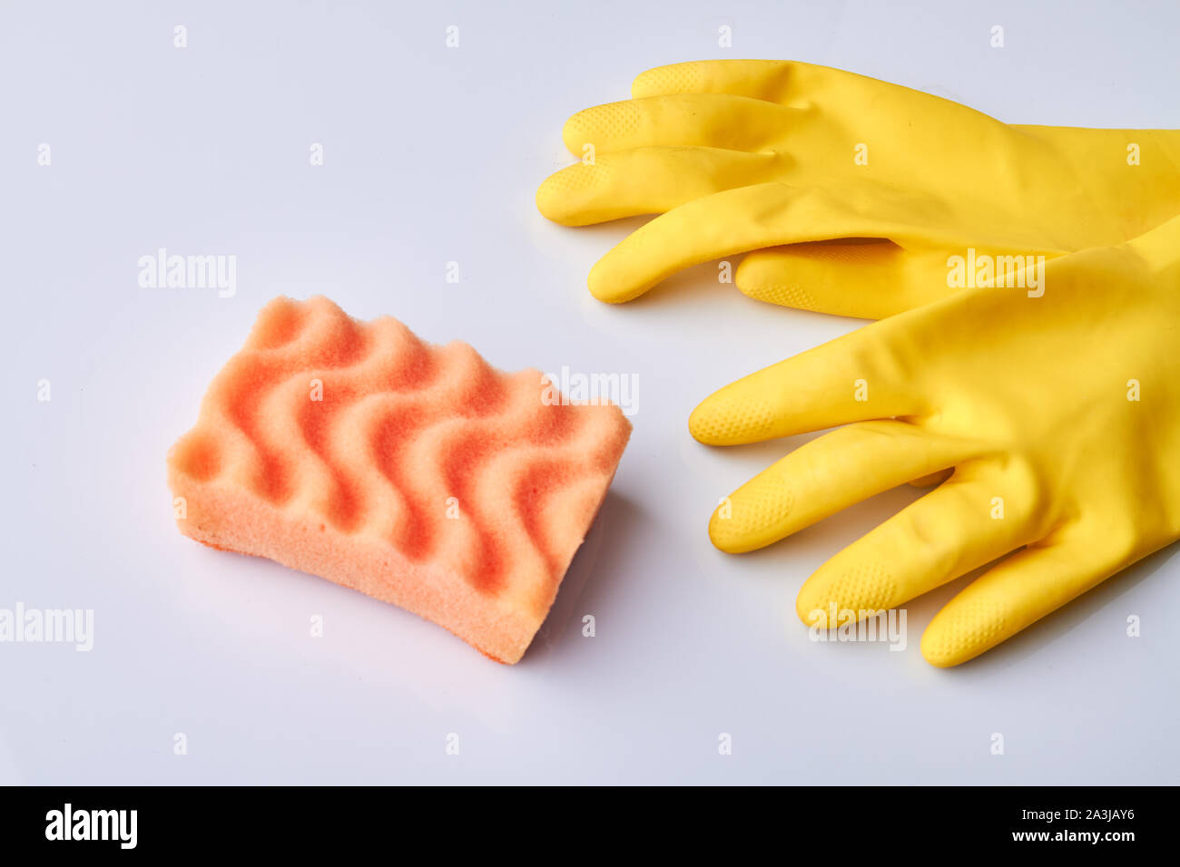 Sponge and gloves on light background Stock Photo - Alamy