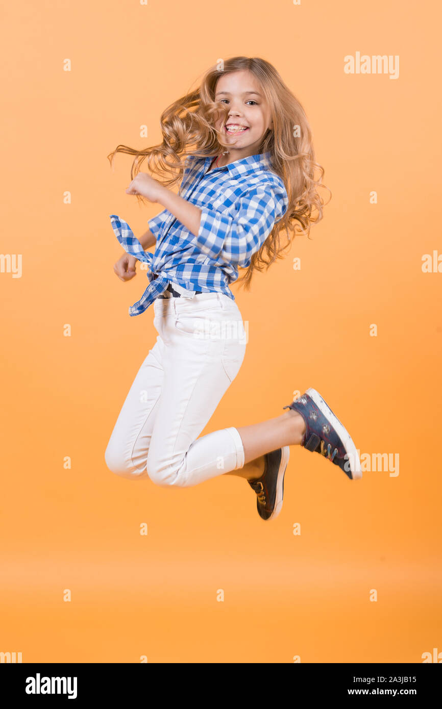 Child jump smiling on orange background. Child bounce with happy face ...