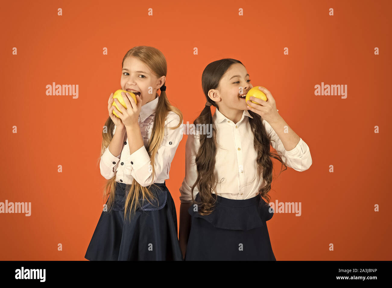 Schoolgirls eat apples. School lunch. Vitamin nutrition during school ...