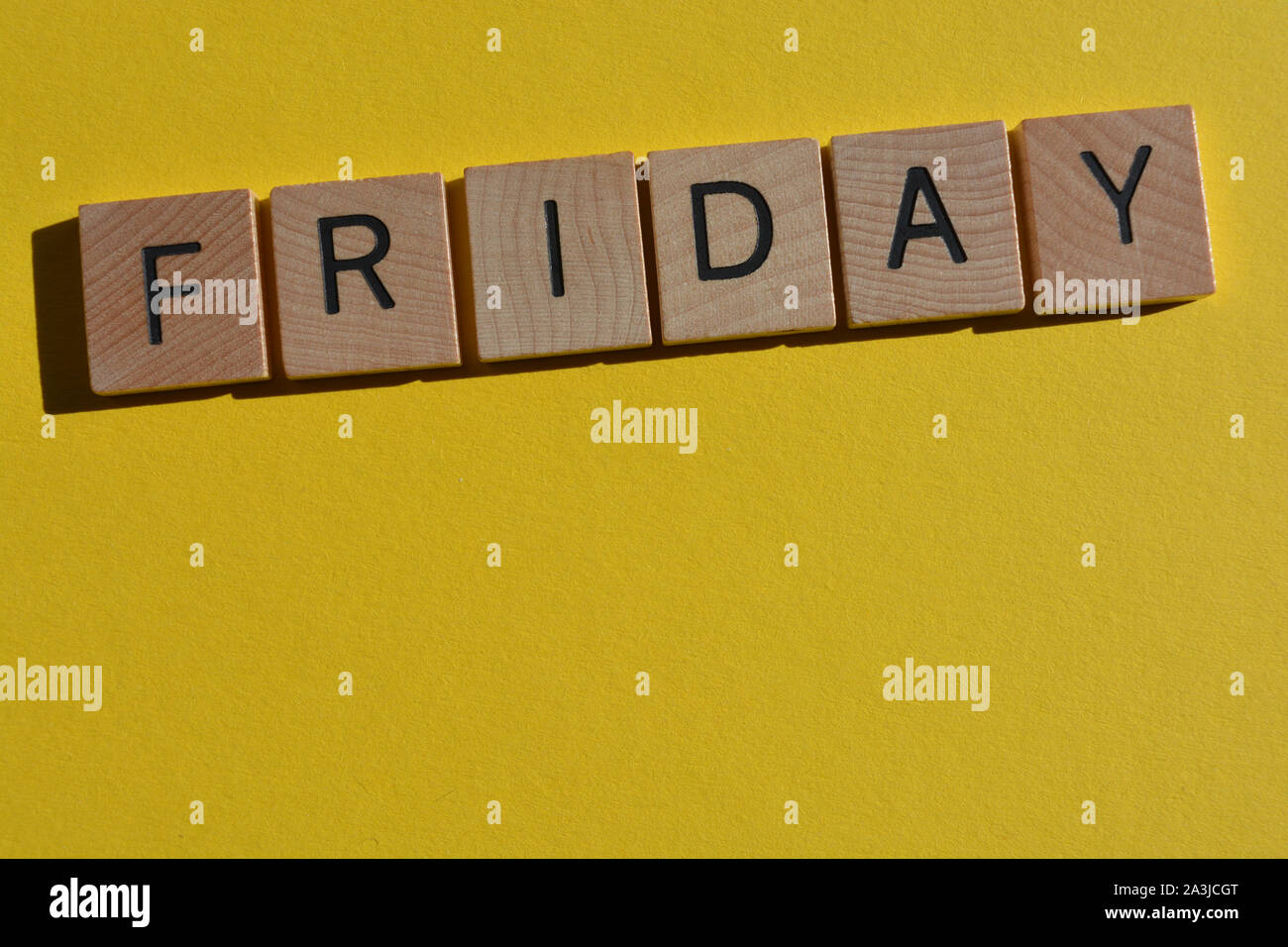 Friday in 3d wooden alphabet letters on a bright yellow background with ...