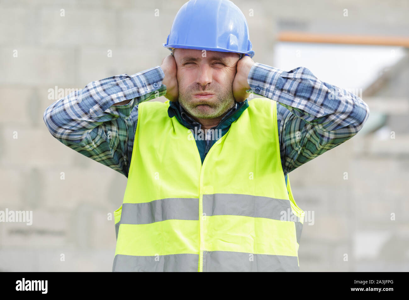 construction worker or engineer covering his ears Stock Photo - Alamy
