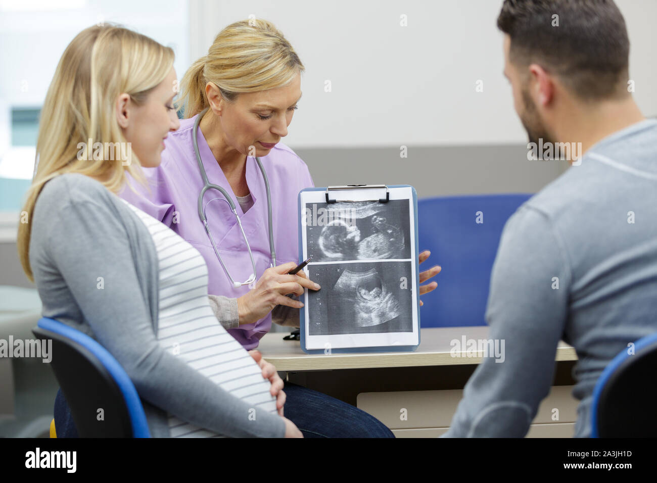 doctor showing couple the scan pictures of unborn baby Stock Photo - Alamy