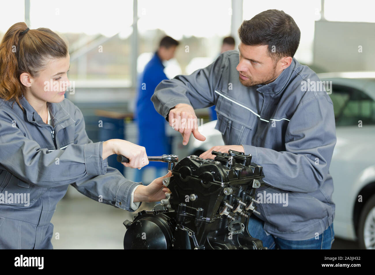 mechanic guiding apprentice working on engine Stock Photo - Alamy