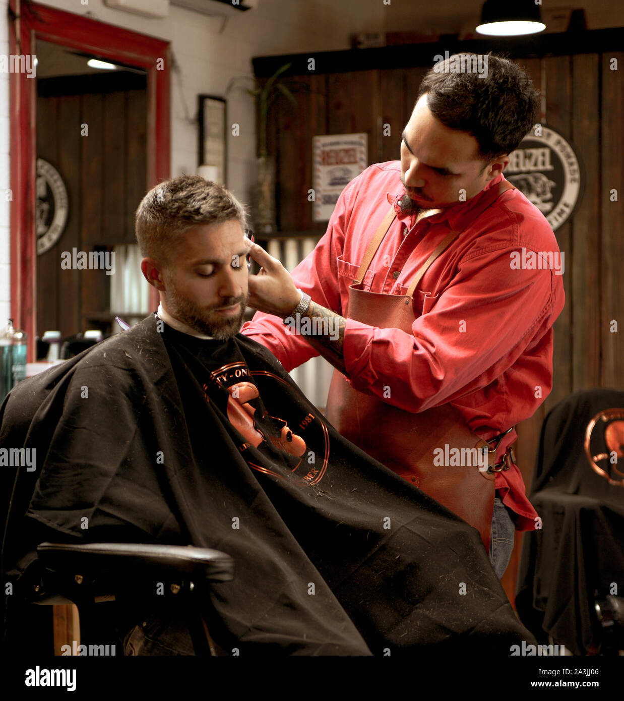 Trendy, handsome, millennial barber, creates a hip haircut for young ...