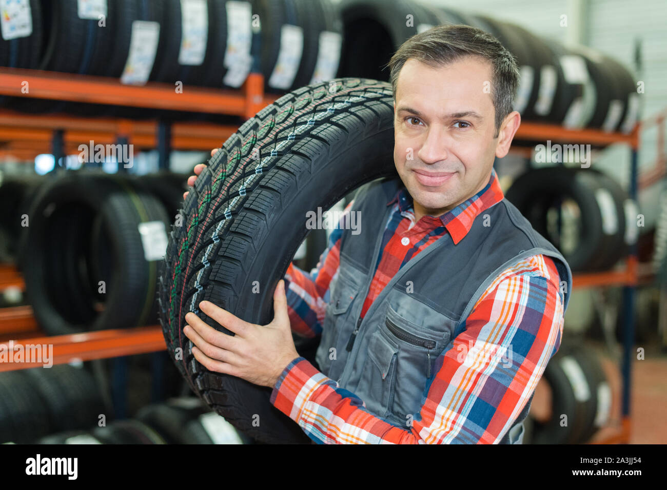 picture of a man carrying a tire Stock Photo - Alamy