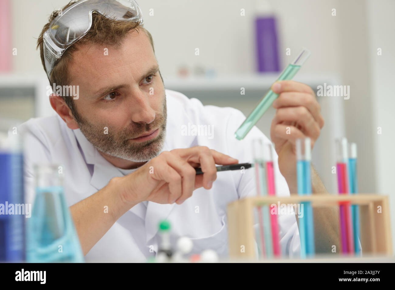 male scientist examining test tube Stock Photo - Alamy