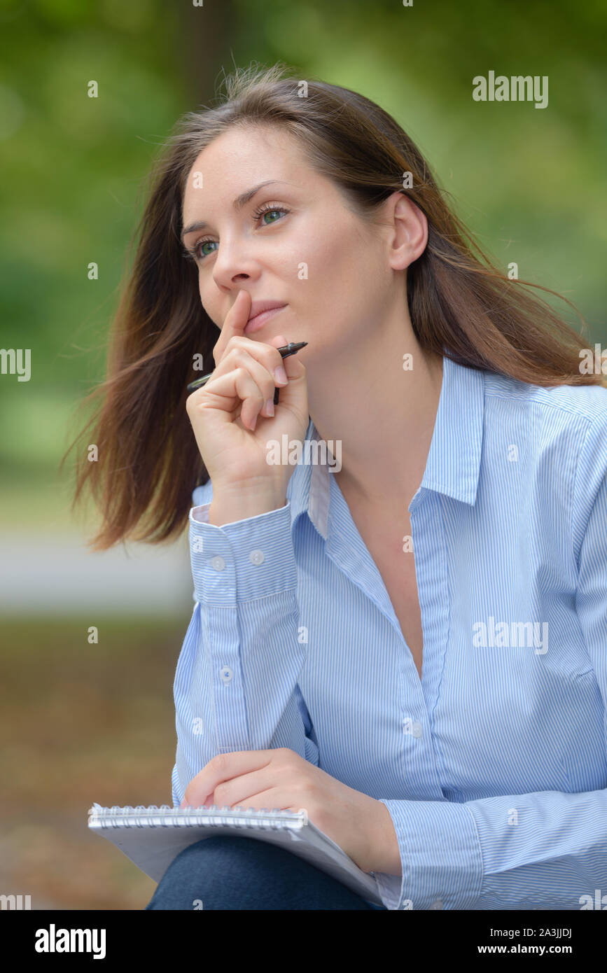 pensive female writing notes in her journal at the park Stock Photo - Alamy