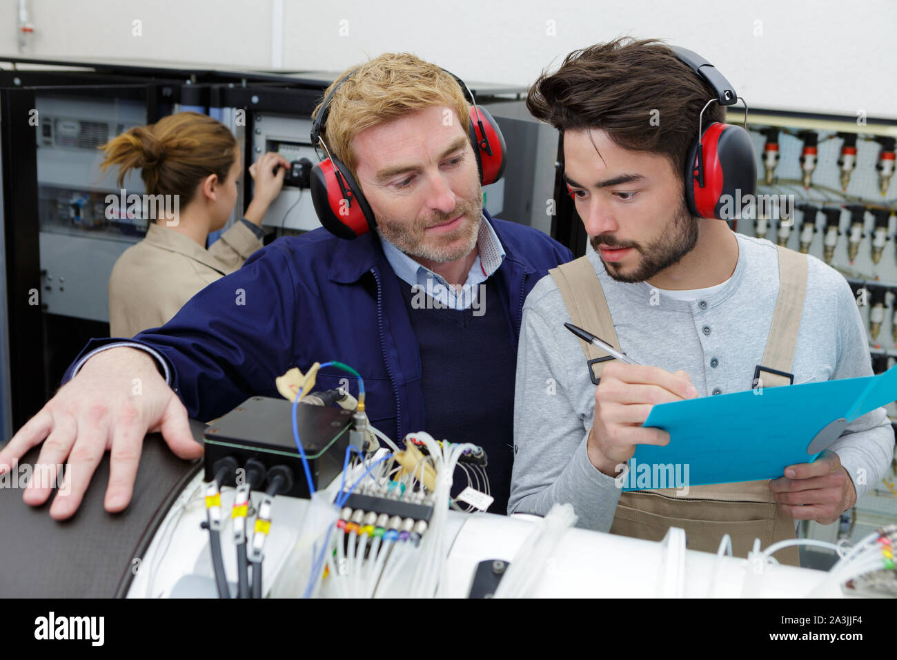 apprentice aviation engineer taking notes with tutor Stock Photo - Alamy