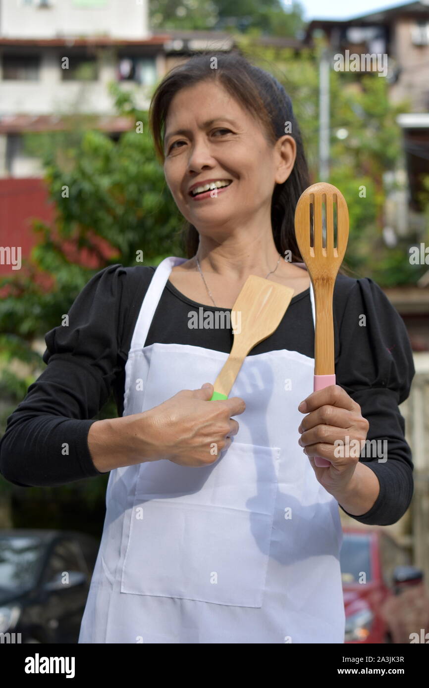 Female Cook And Happiness With Kitchen Utensils Stock Photo - Alamy