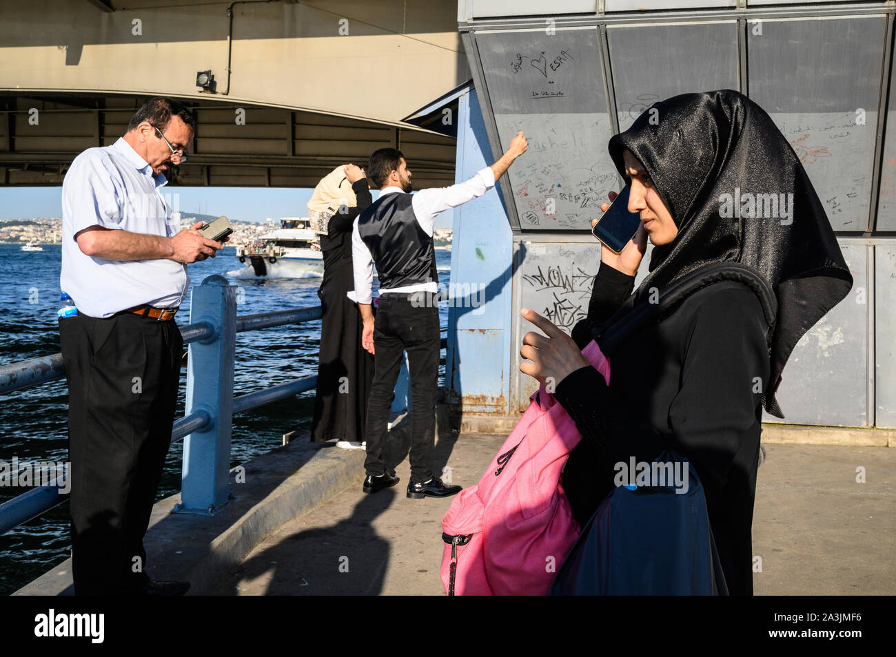 People using their mobile phones on Galata Bridge, Istanbul, Turkey ...
