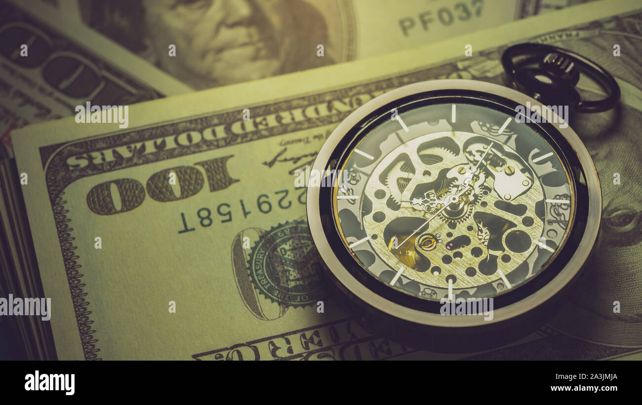 Pocket watch and dollar banknote stacking in darkness background ...