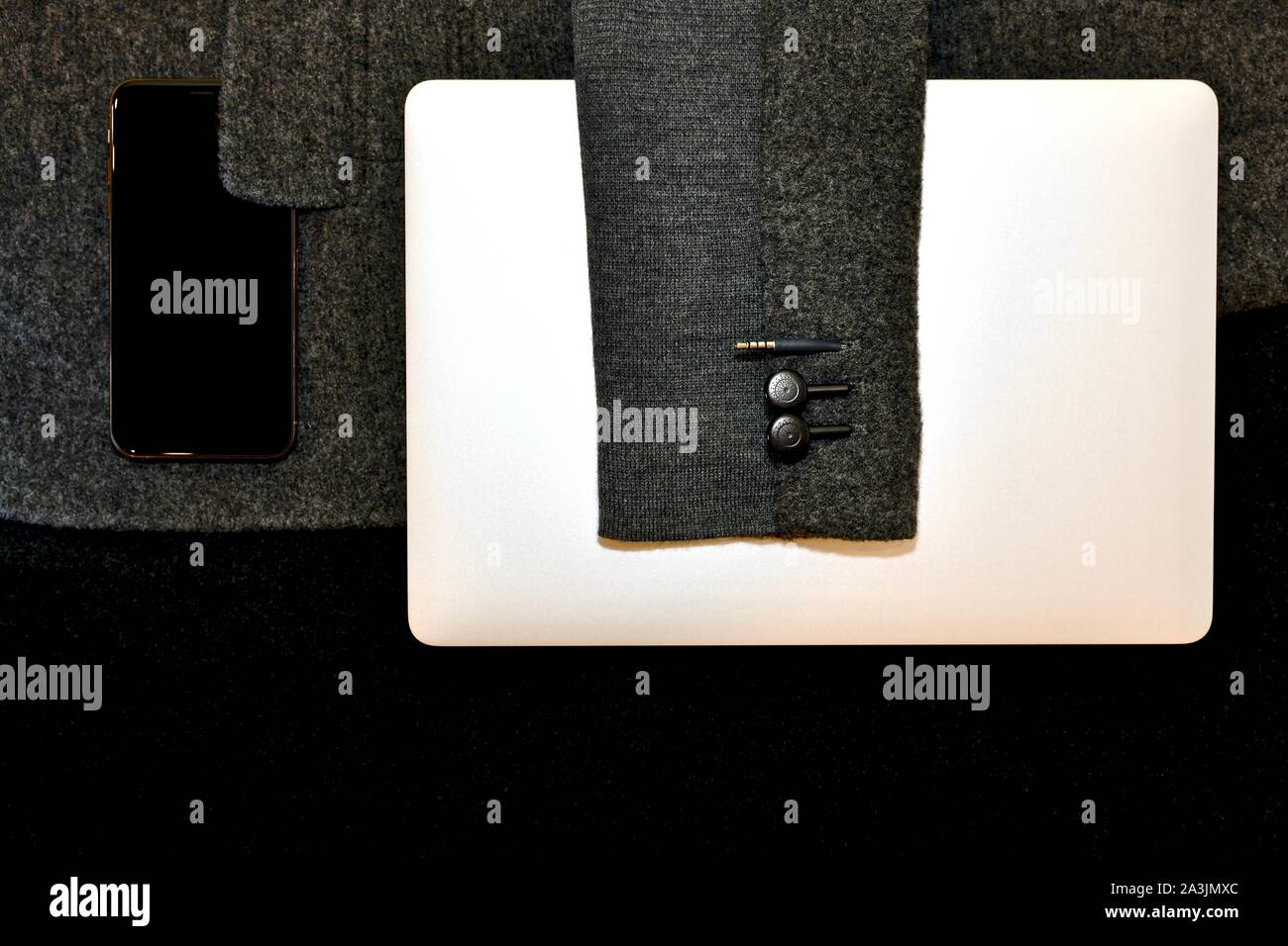 Laptop and smartphone on a gray jacket Stock Photo - Alamy
