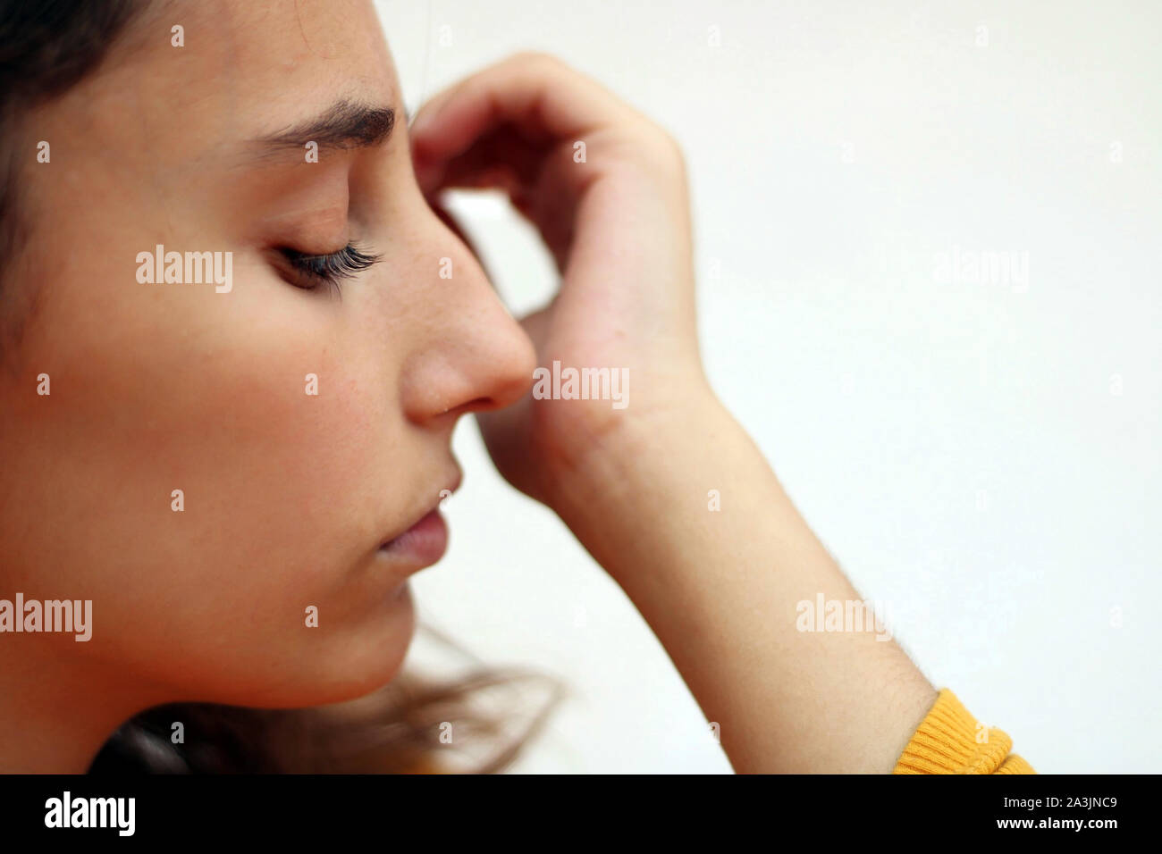 Pretty young girl smelling a perfume that has been thrown on her wrist ...