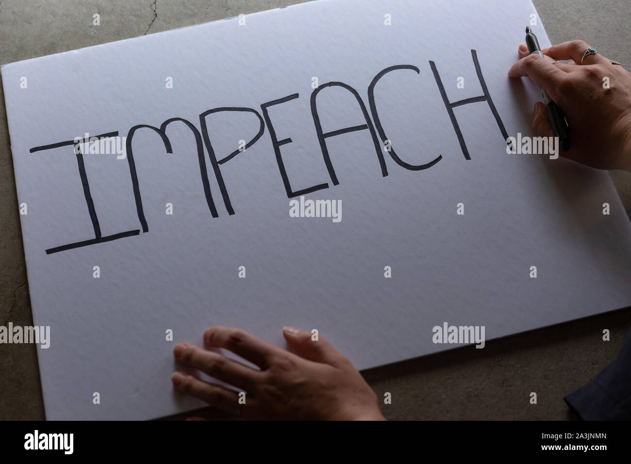 Hands of anonymous female making protest sign that says Impeach Stock ...