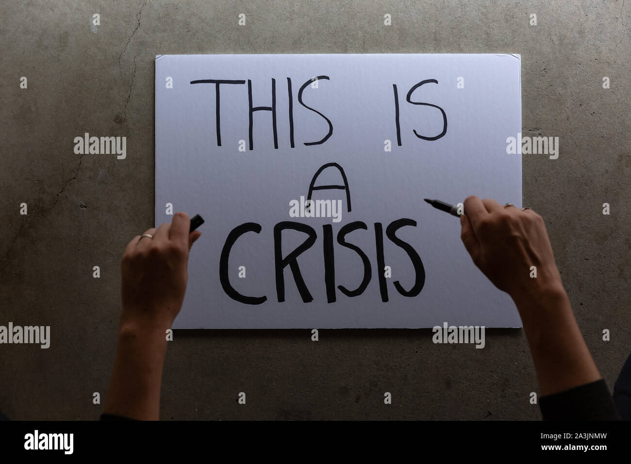 Anonymous female making protest sign that says This is a crisis Stock ...