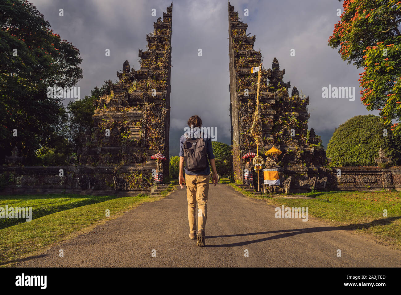 Tourist man walking through Traditional Balinese Hindu gate Candi ...