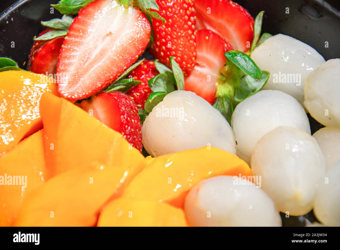 Bento box of fruits as Mango lychee and strawberries Stock Photo - Alamy