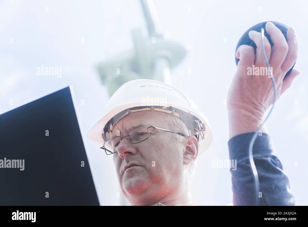 older energy engineer in front of a wind turbine Stock Photo - Alamy