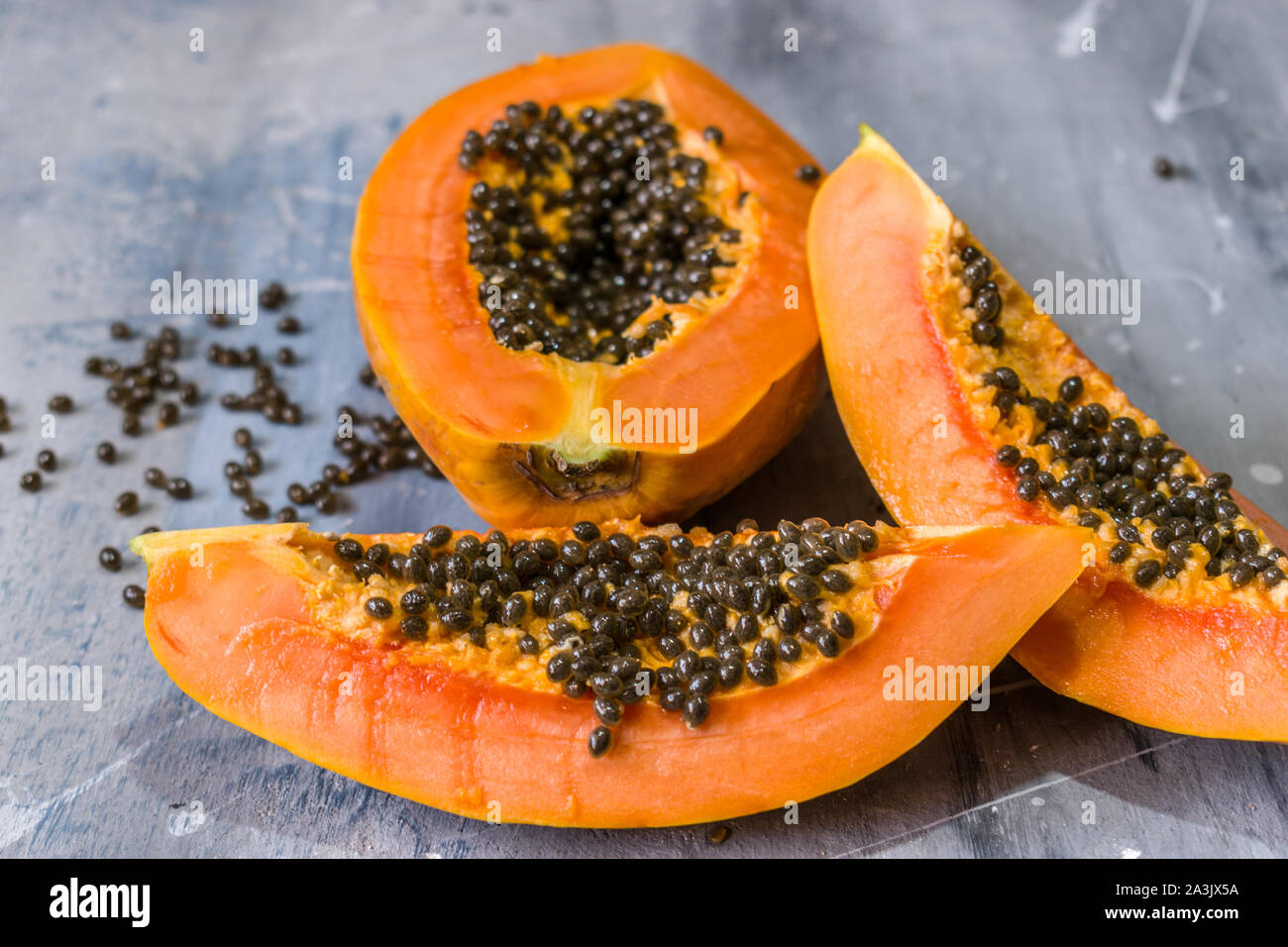 papaya cut into three pieces Stock Photo - Alamy