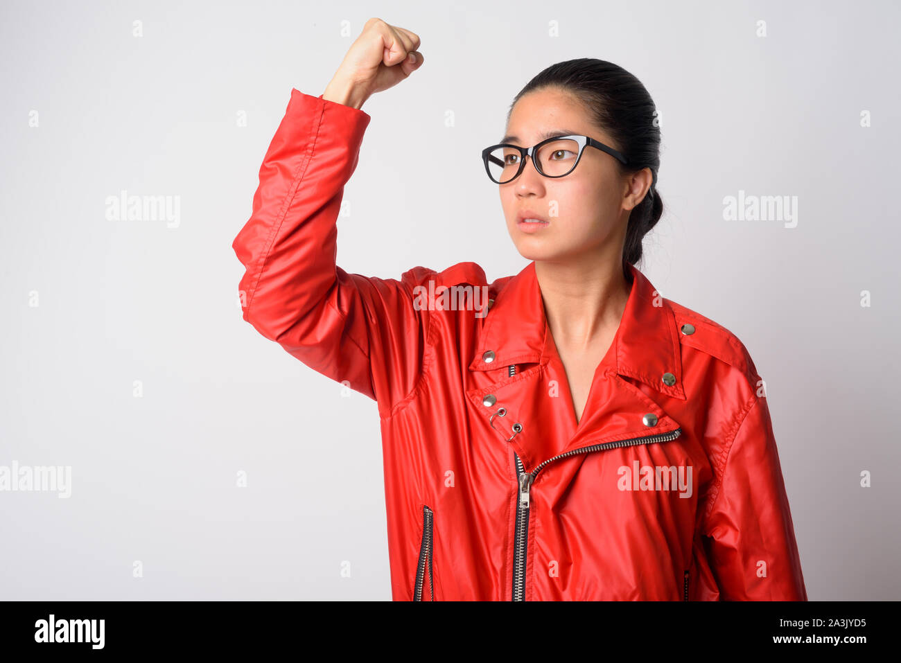 Portrait of young Asian rebellious woman with fist raised Stock Photo ...