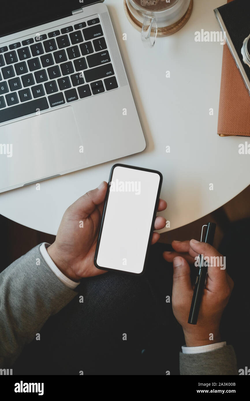Top view of young businessman holding blank screen smartphone while ...