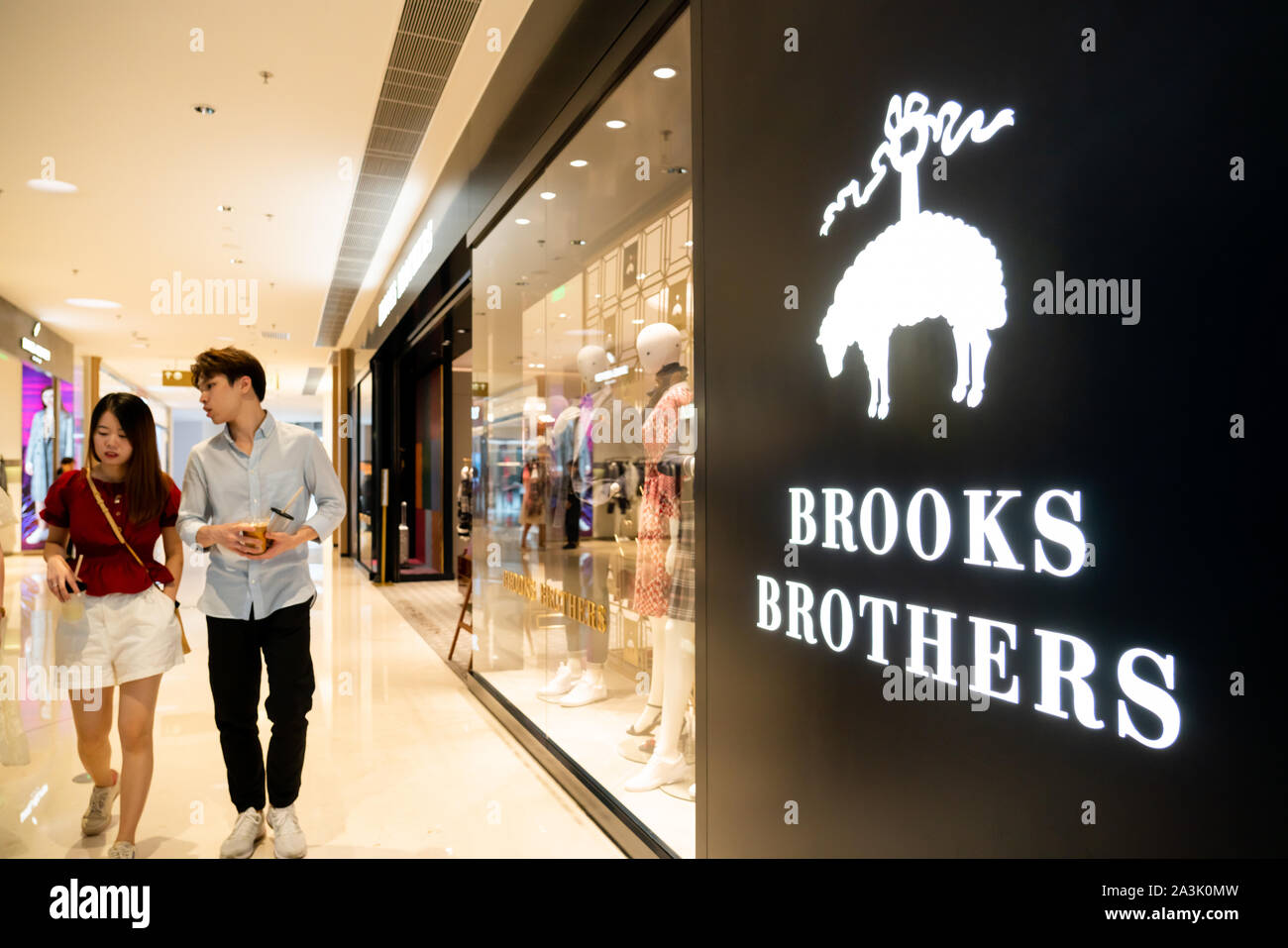 Pedestrians walk past an American men's clothier chain Brooks Brothers ...