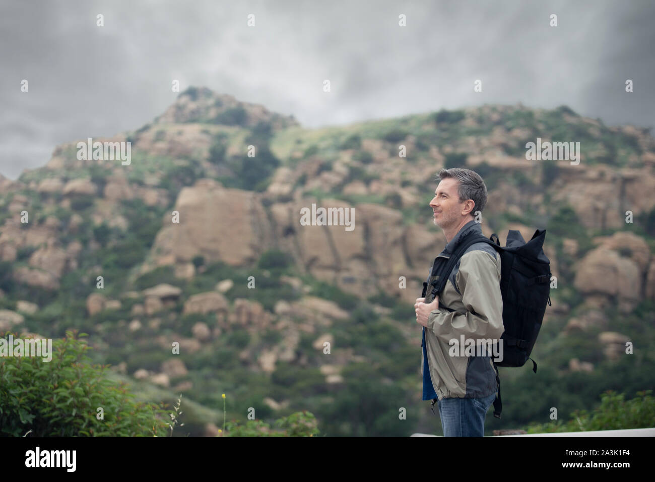 Middle-aged Caucasian male hiker trekking alone in the mountains. The ...