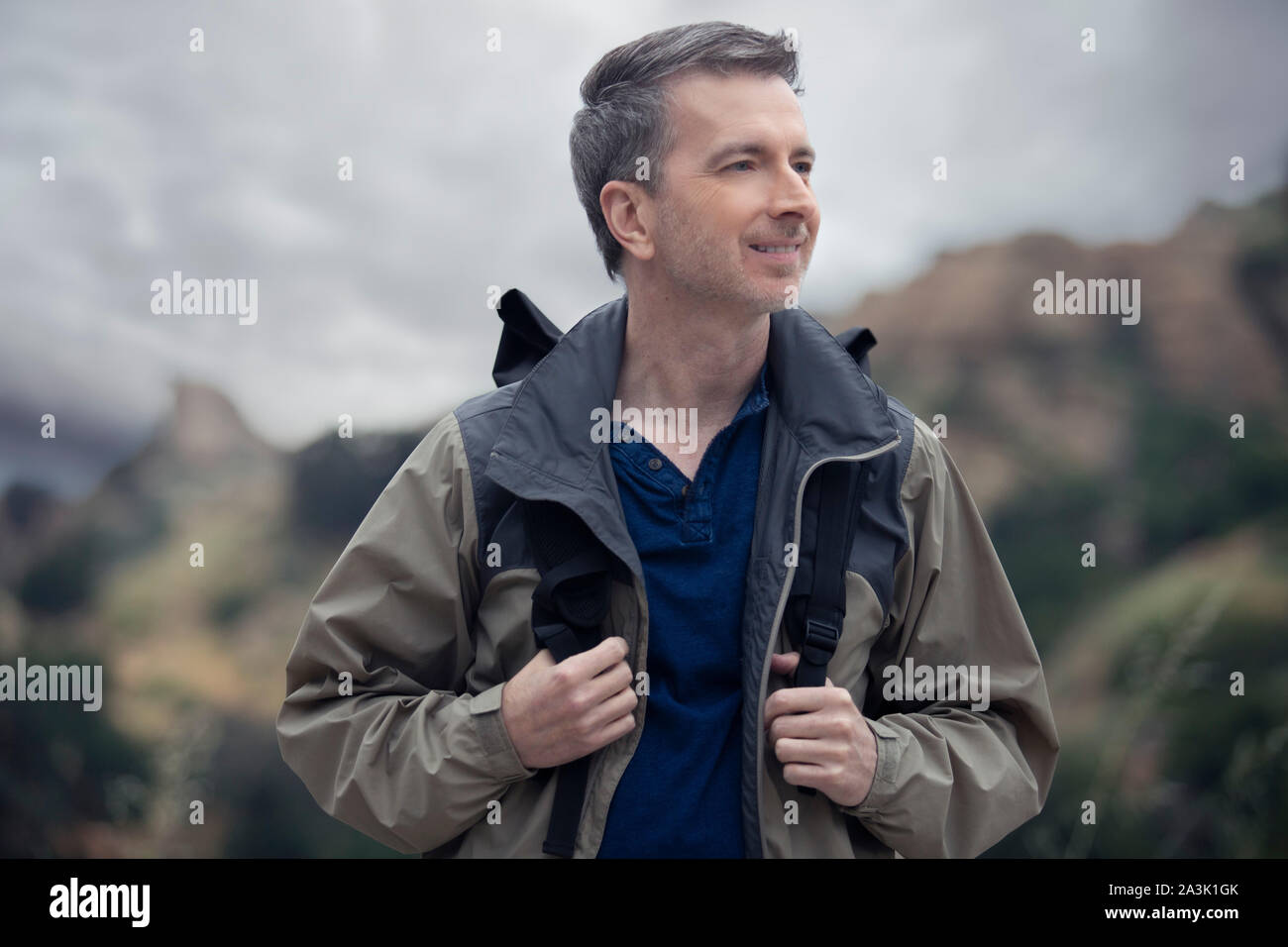 Middle-aged Caucasian male hiker trekking alone in the mountains. The ...