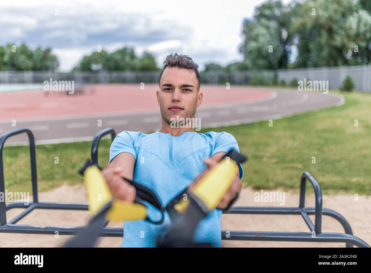 Male athlete, loops straps training chest muscles, exercise arms ...